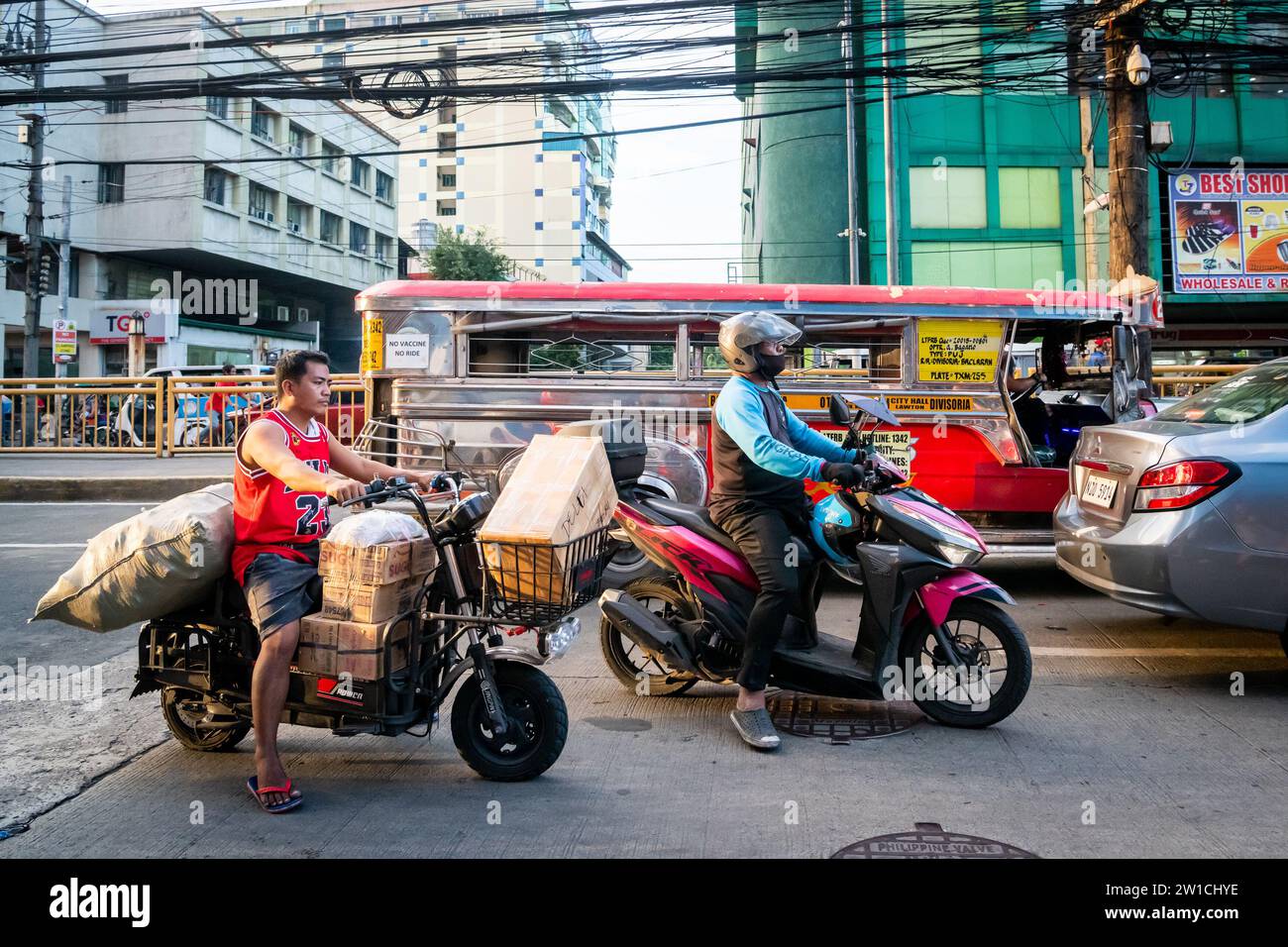 A typical busy street scene in Manila. Traffic is heavy with supplies being taken to the local ...