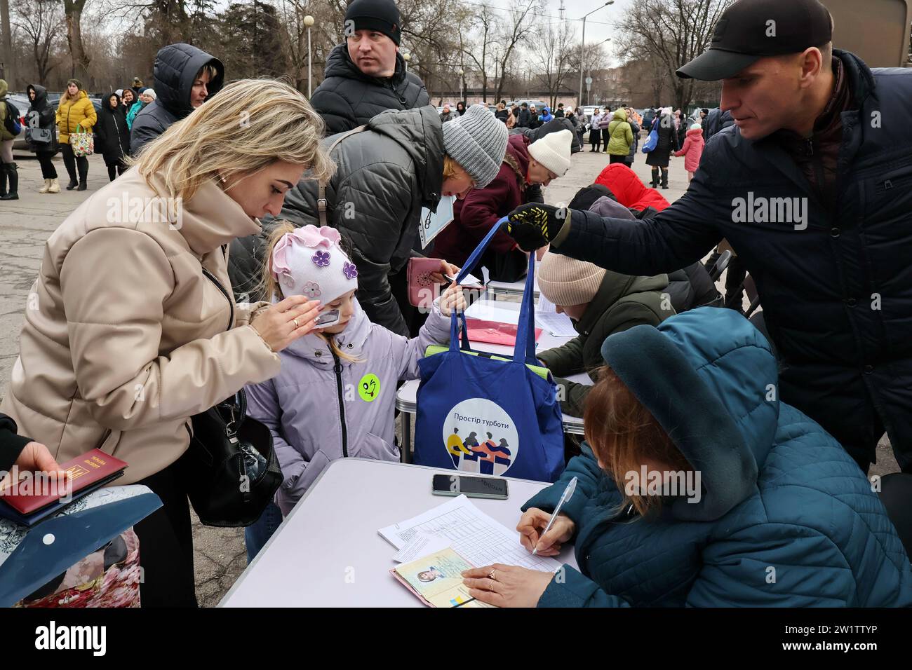People receive humanitarian aid at a distribution point in Zaporizhzhia ...