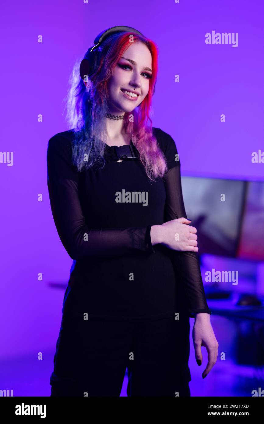 Portrait of a smiling e-sport gamer girl in front of her computer in ...