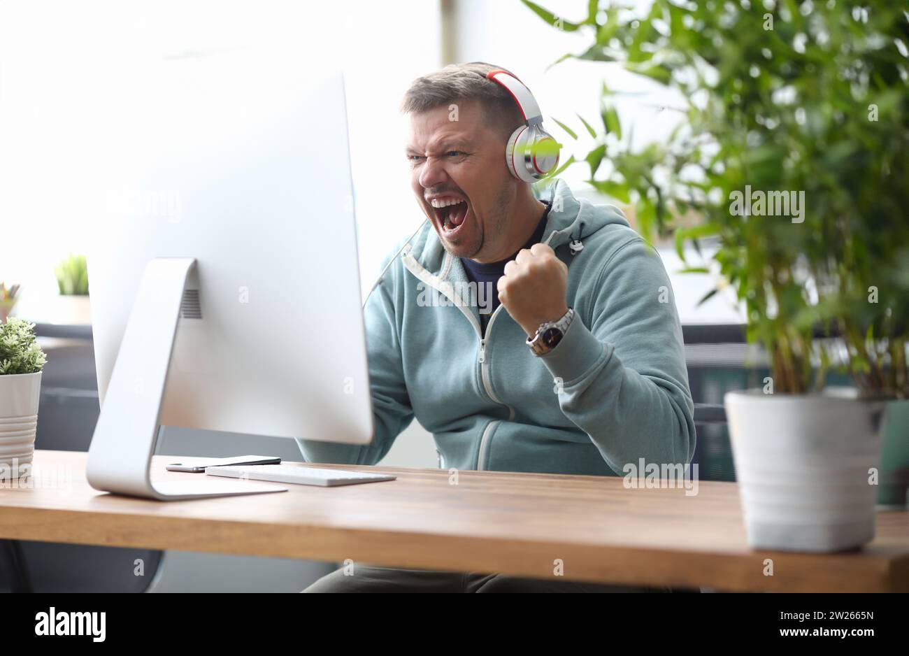 Man screaming in computer monitor sitting Stock Photo - Alamy