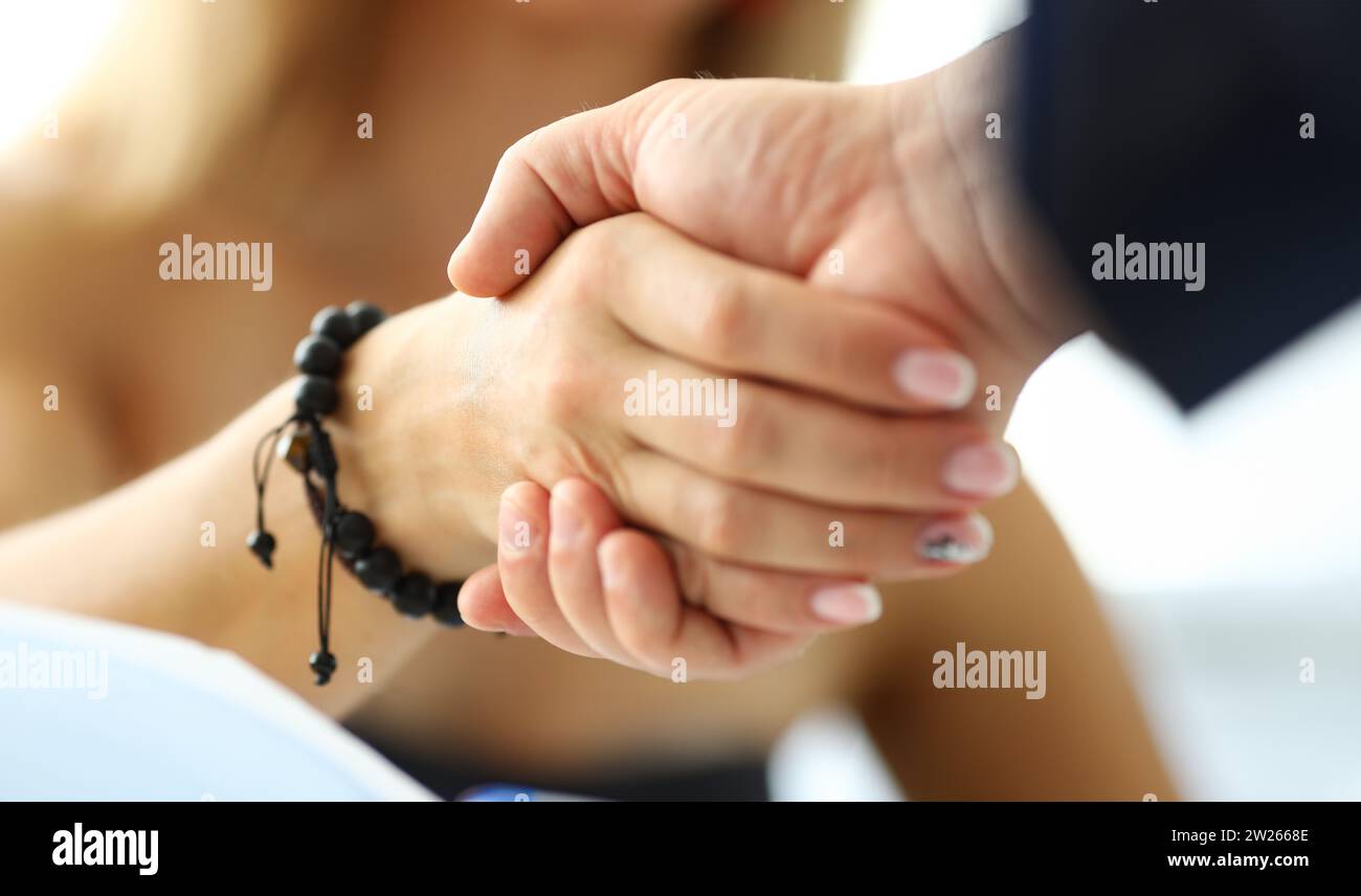 Man and woman shaking arms as successful bargain Stock Photo - Alamy