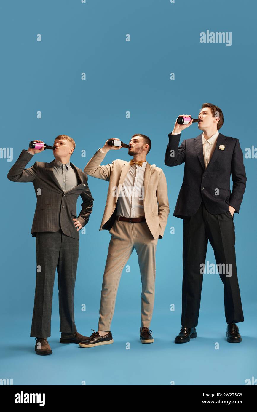 Handsome men in stylish suits, friends attending party, drinking beer ...