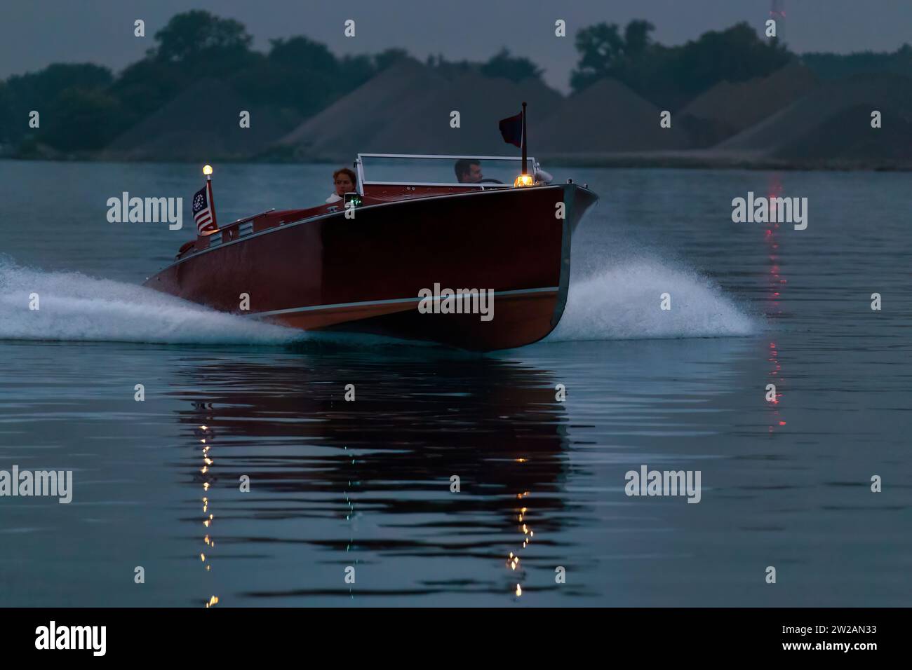 Two people riding in a vintage speedboat in the early dawn Stock Photo ...