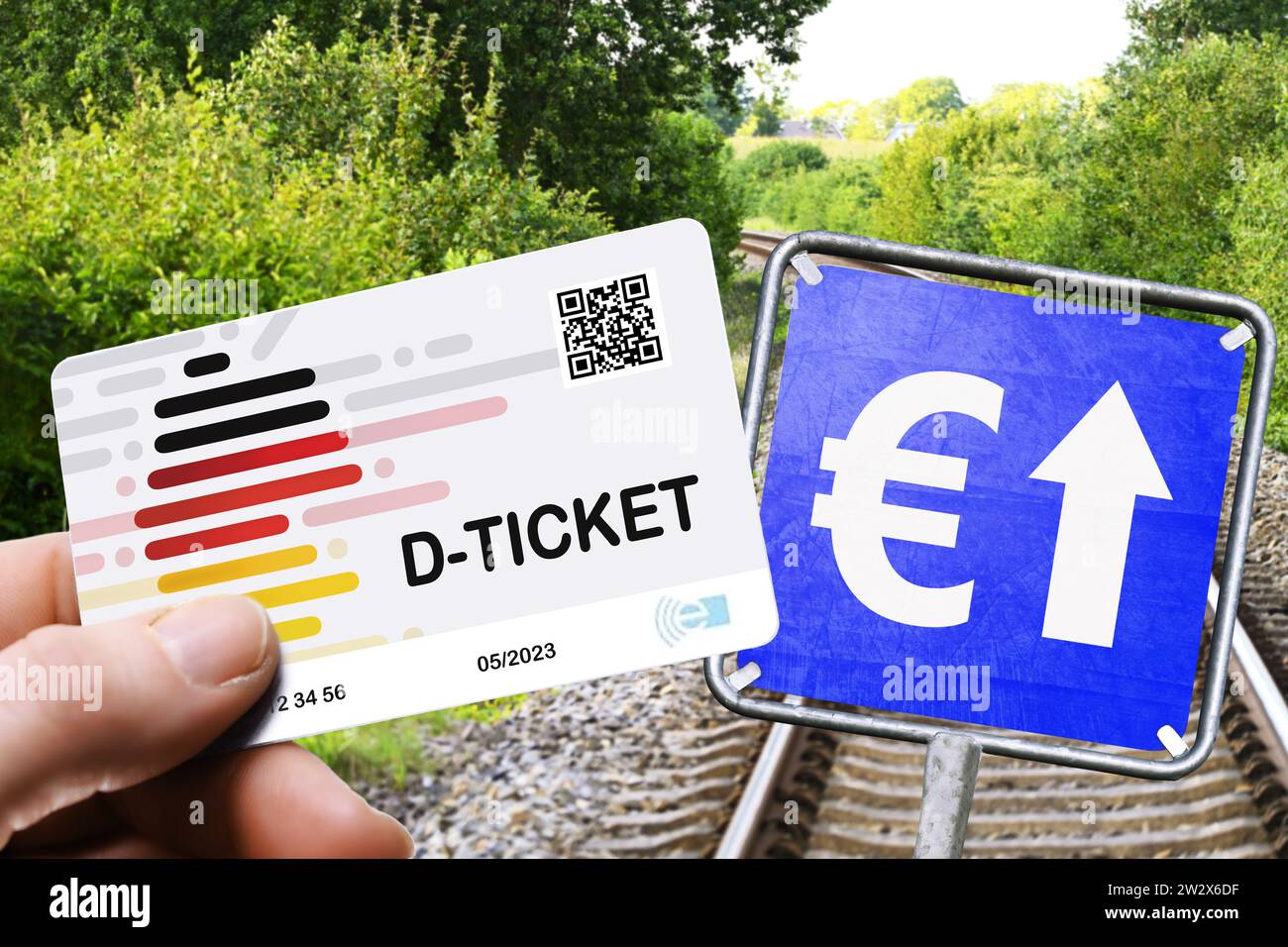 FOTOMONTAGE, Hand hält 49-Euro-Ticket vor Bahnschienen und Schild mit ...