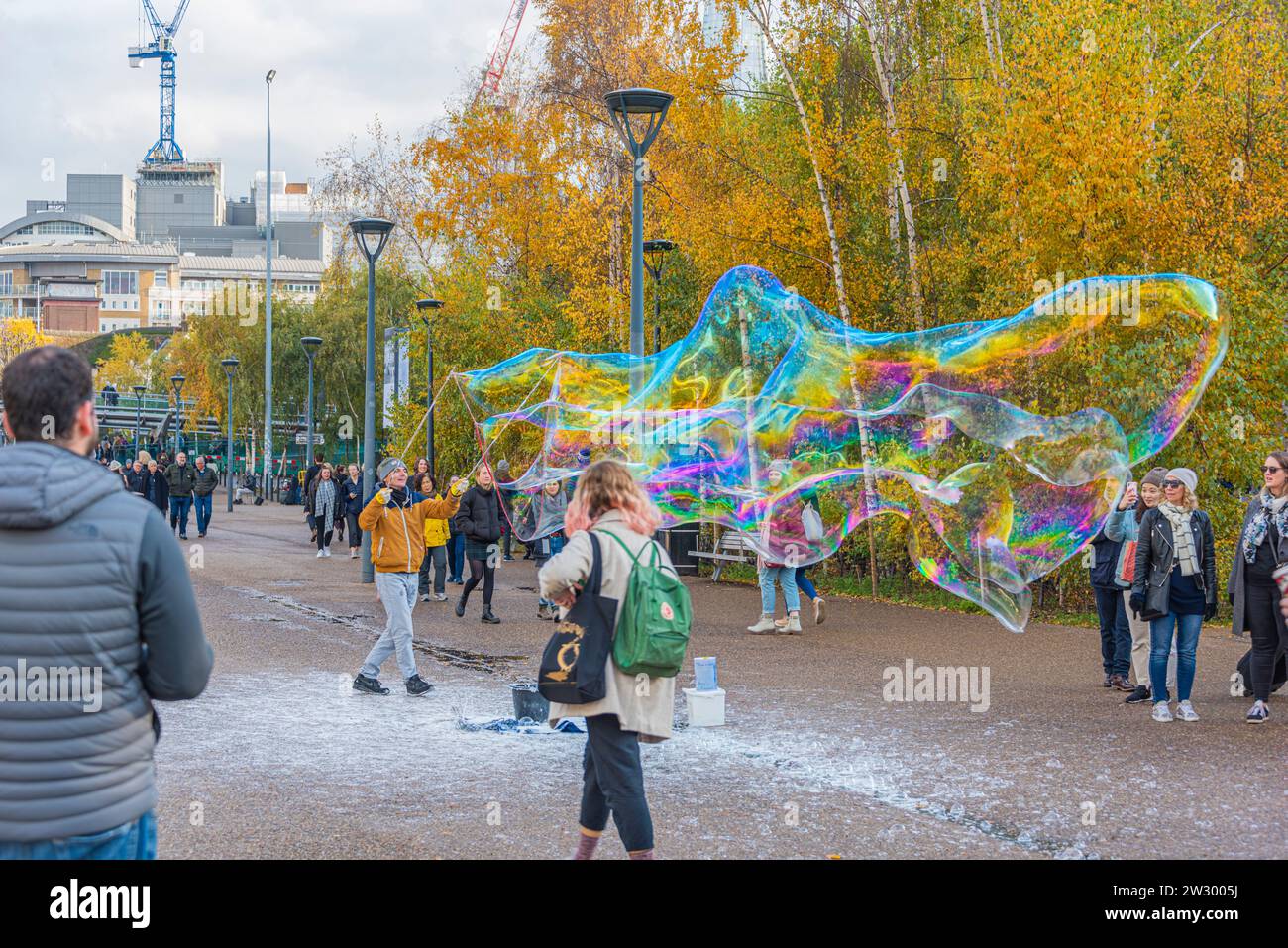 Kids enjoying colourful bubbles created by street entertainer, Bankside ...