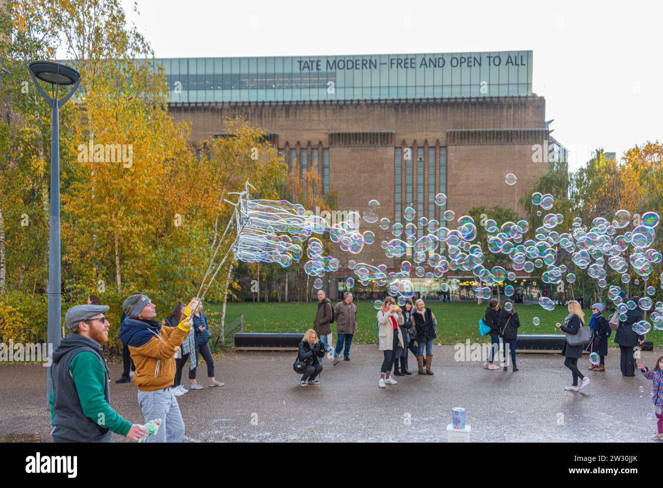 Kids enjoying colourful bubbles created by street entertainer, Bankside ...