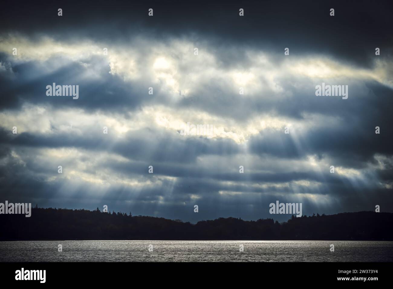 Sonnenstrahlen durchbrechen dunkle Wolken am Großen Pönitzer See in ...