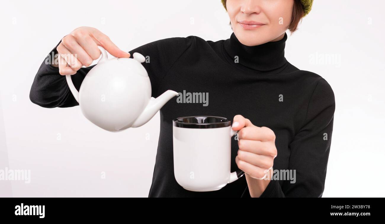 Portrait of a smiling woman pouring tea from a white teapot. Tea ...
