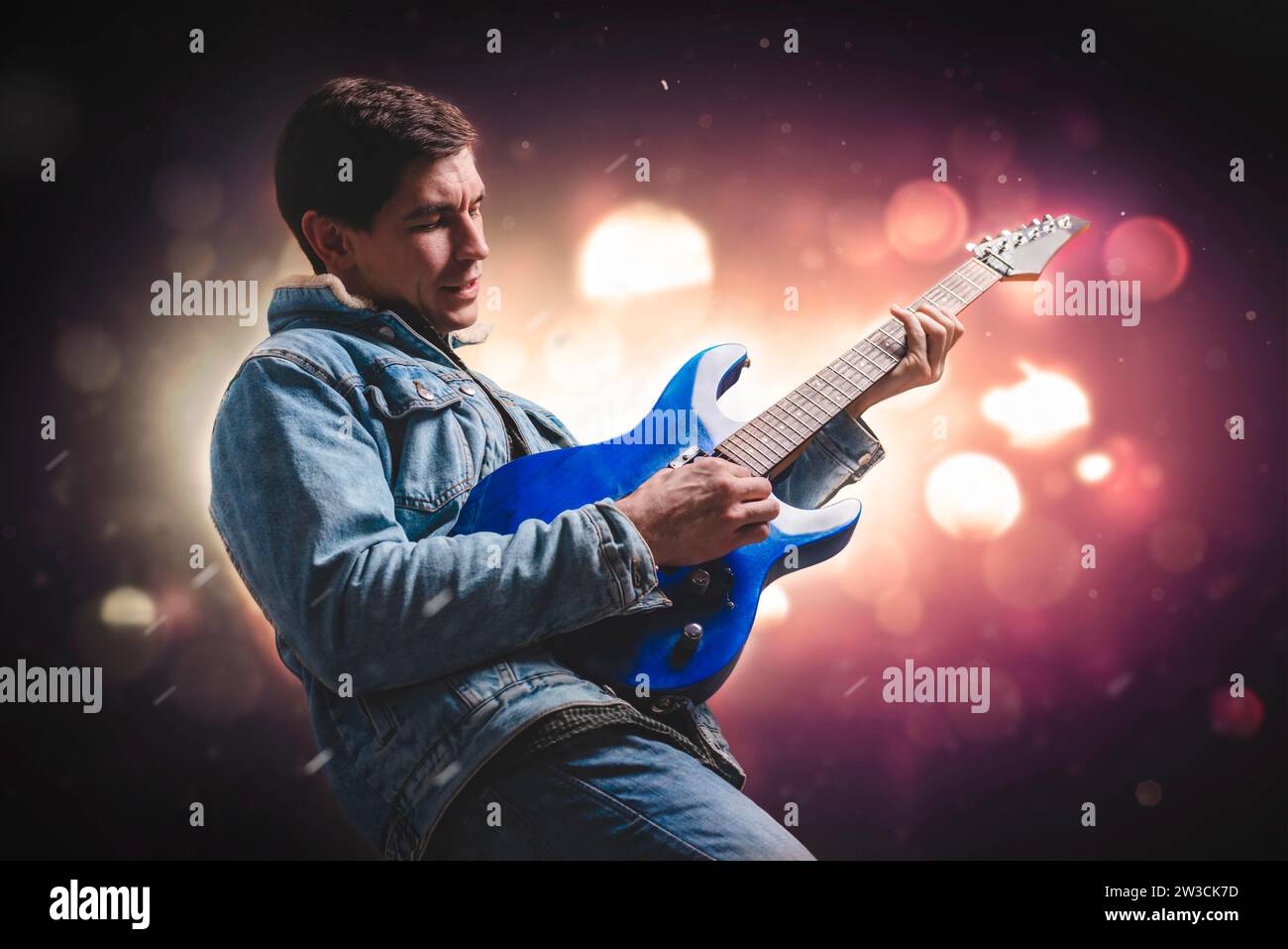 Image of an emotional musician in a denim jacket playing a blue ...