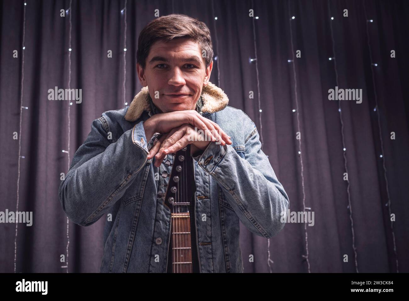 Image of a musician in a denim jacket posing with a guitar. Concerts ...
