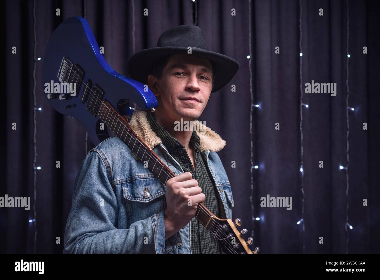 Portrait of a cheerful age guitarist with a guitar on his shoulder ...
