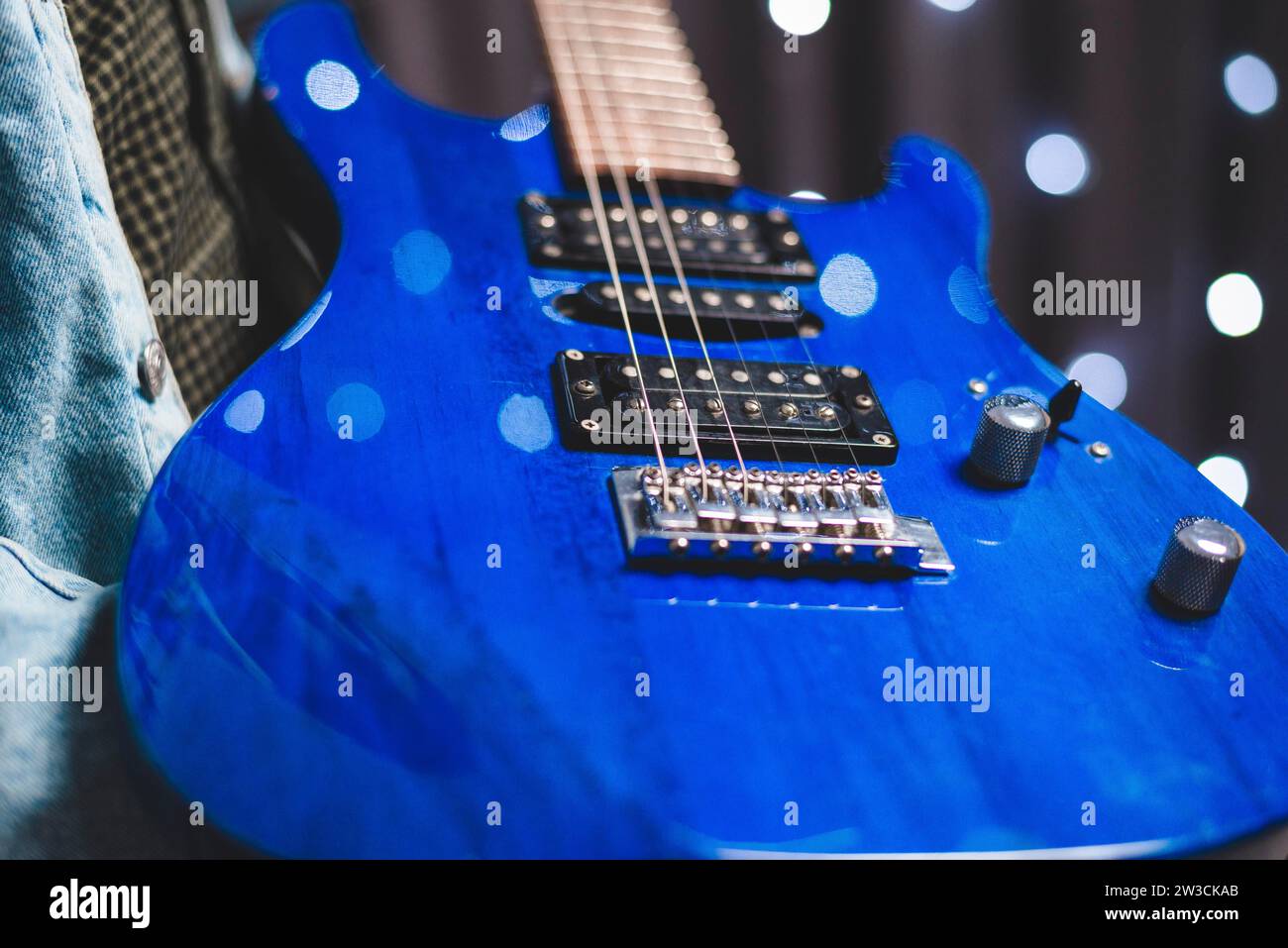 Image of a blue electric guitar close-up. The concept of tuning and ...