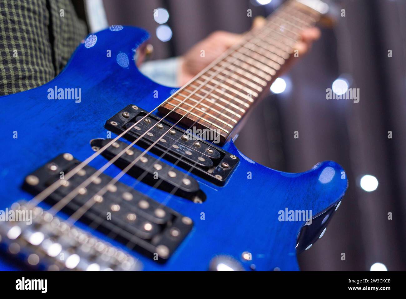 Image of a blue electric guitar close-up. The concept of tuning and ...