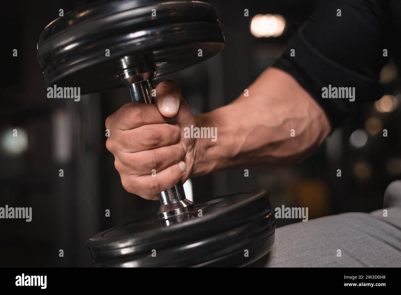 Image of a powerful male hand holding a dumbbell in the gym. Business ...