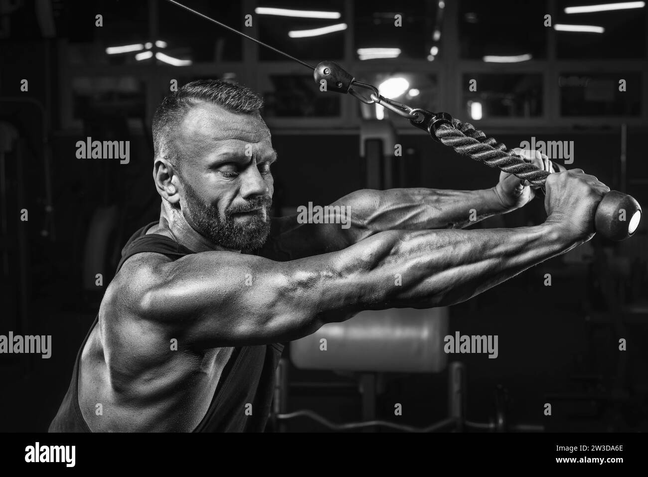 Image of a powerful athlete exercising in a crossover at the gym ...