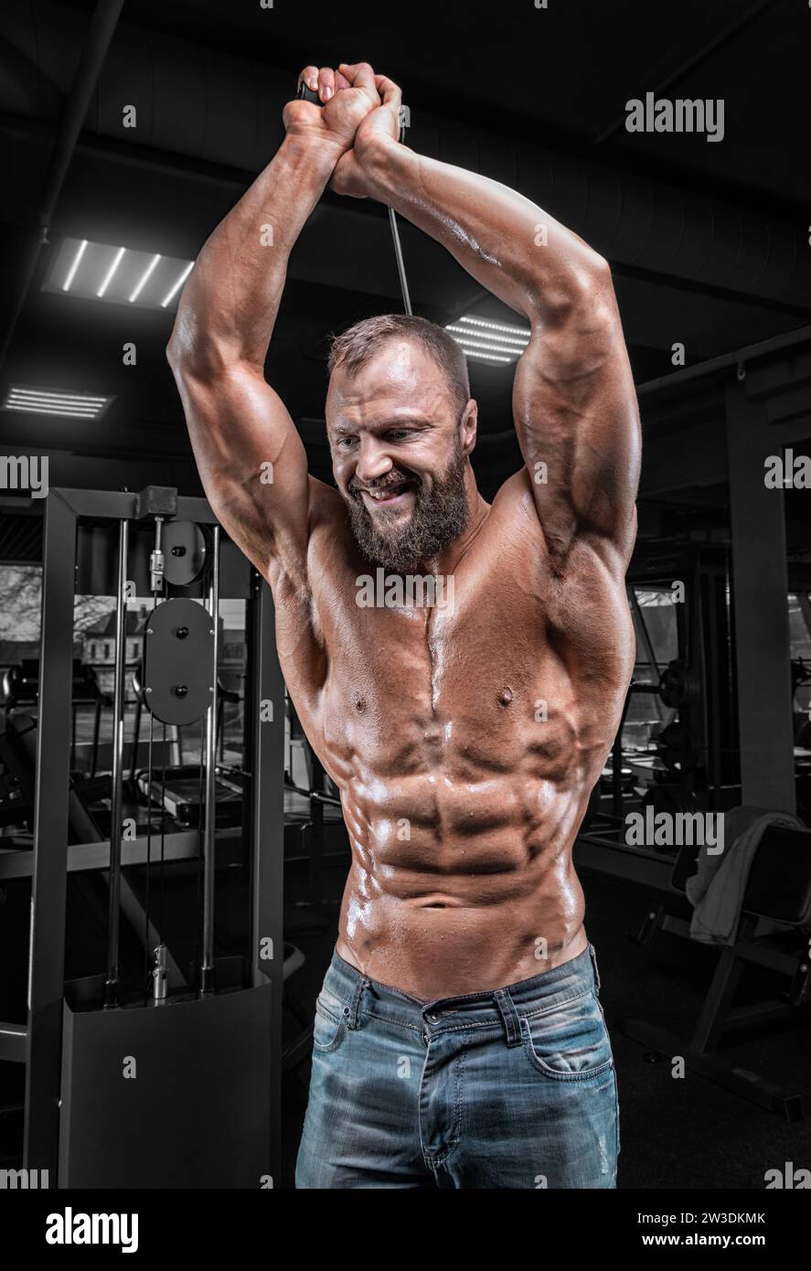 Professional athlete trains with elastic bands in the gym. Bodybuilding ...