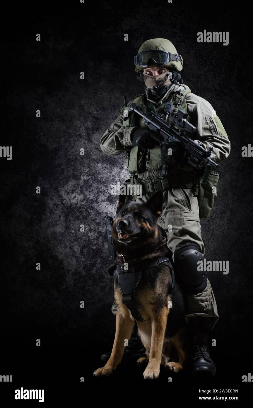 Armed soldier of a special unit with a machine gun stands with his ...