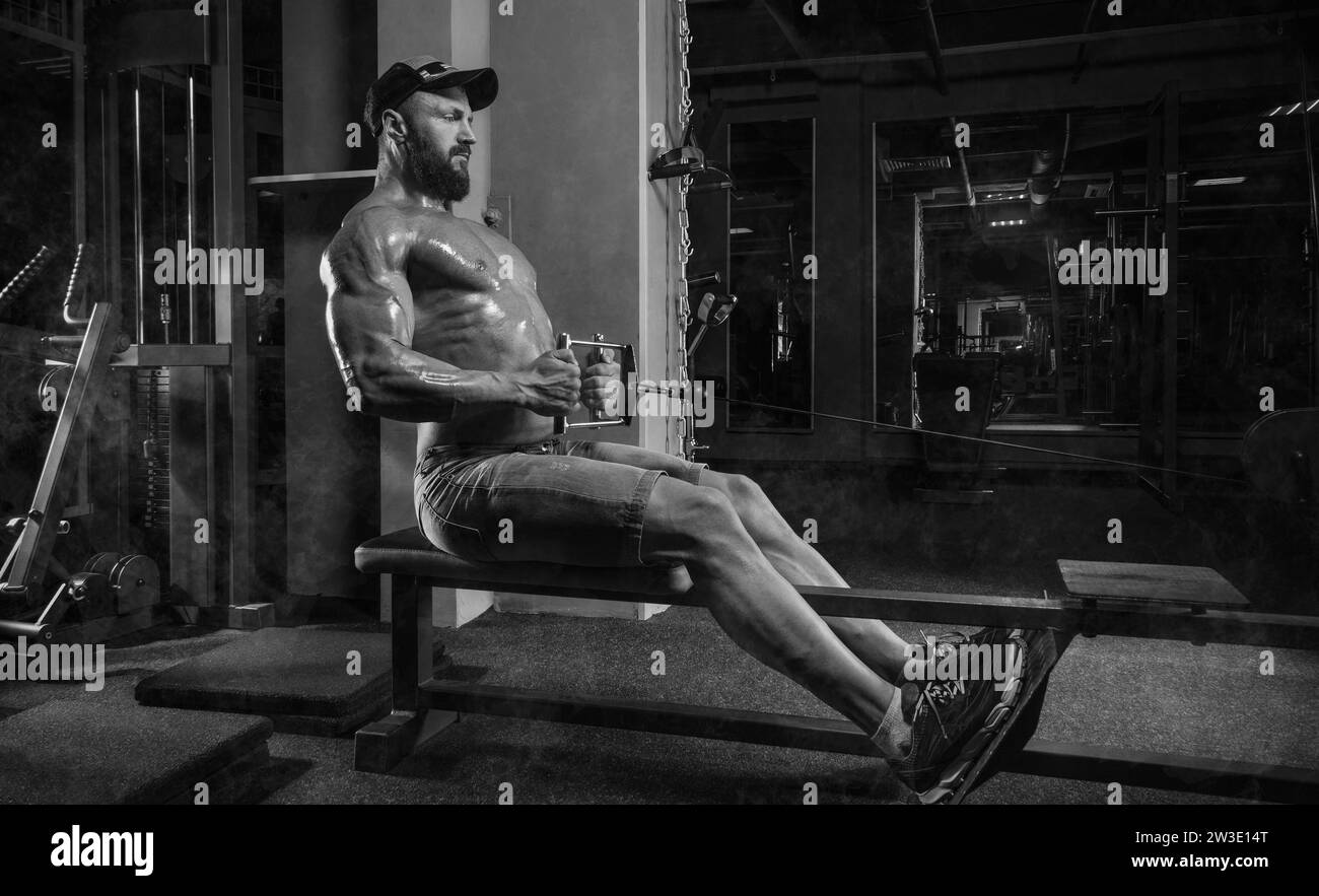 Muscular athlete trains in the gym. Back pumping in the block. Fitness ...