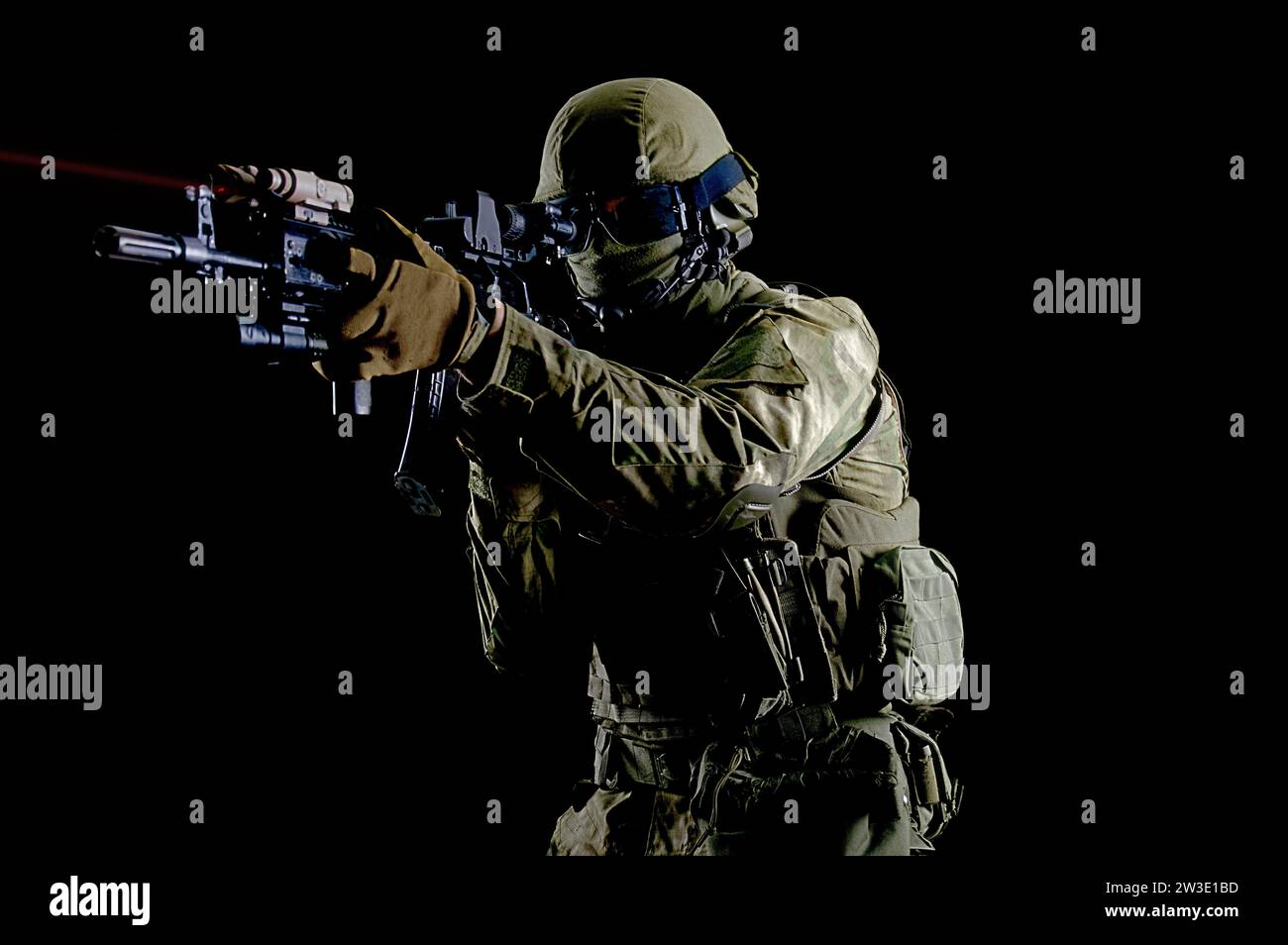 American soldier in combat ammunition with a weapon equipped with laser ...