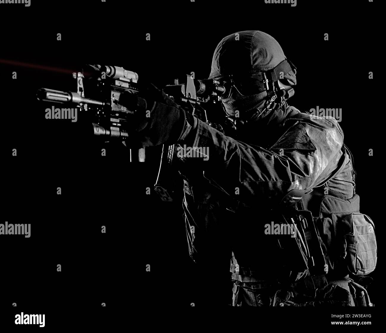 American soldier in combat ammunition with a weapon equipped with laser ...