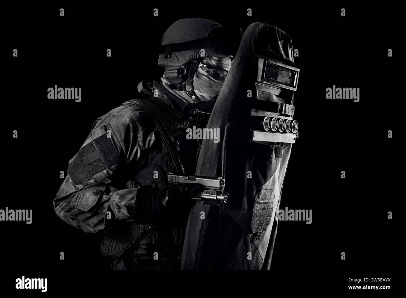 Armed with a pistol, a military man in a bulletproof vest covers ...