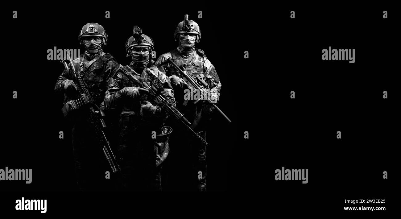 Three soldiers in uniform with a weapon in their hands are looking ...
