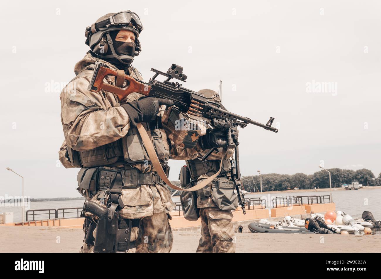 Soldier of a special forces group stands with a heavy machine gun ...