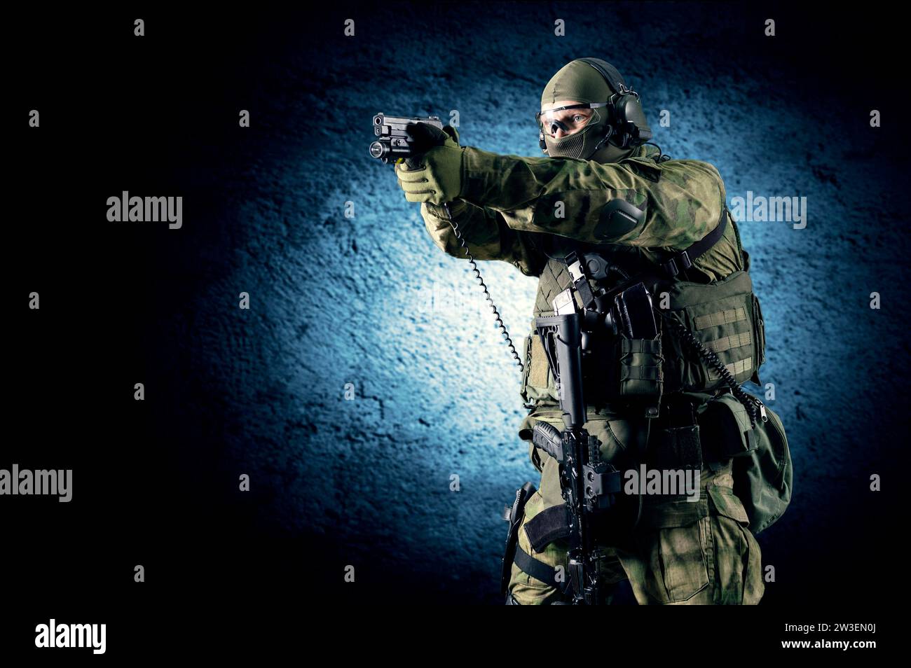 Special unit soldier stands with a pistol in his hands and aims at the ...