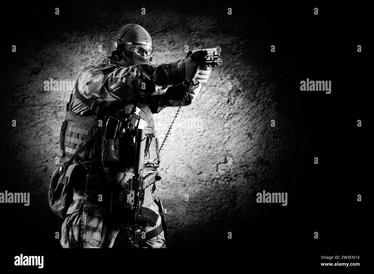 Special unit soldier stands with a pistol in his hands and aims at the ...