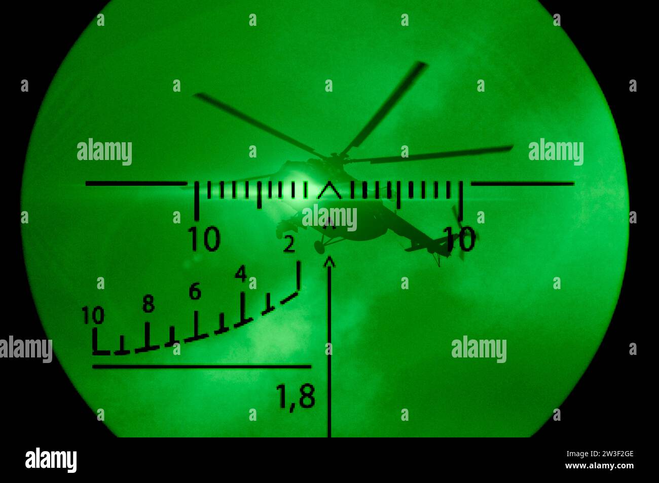 Military helicopter in the optical sight of a sniper rifle. Green light ...