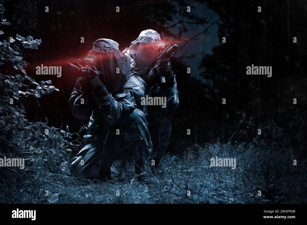 Two fighters of a special unit move through the forest at night. The ...
