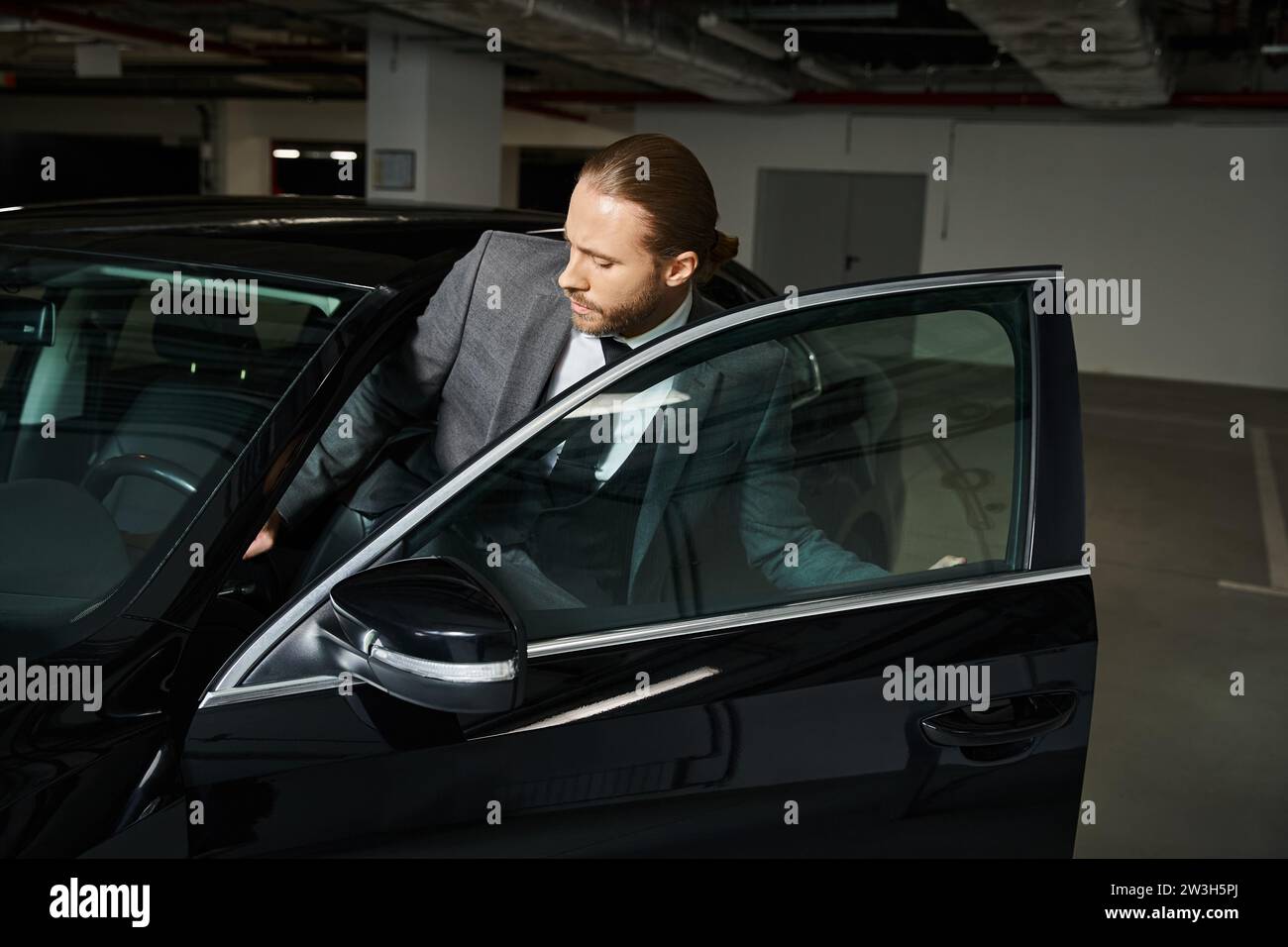 attractive elegant man in chic smart suit getting into his car on ...