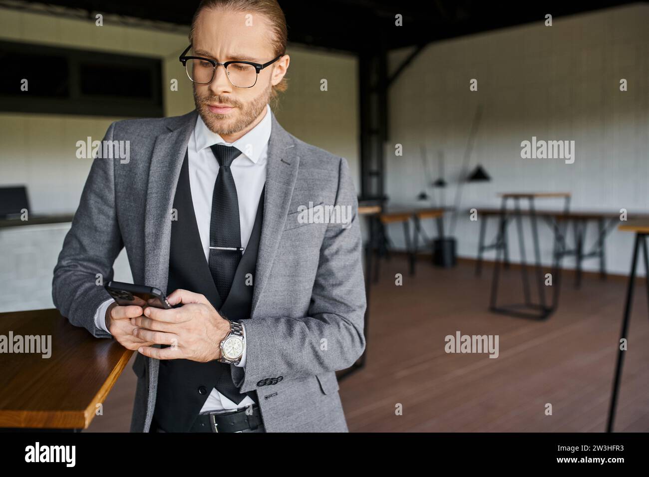 handsome professional in smart gray suit looking attentively at his ...