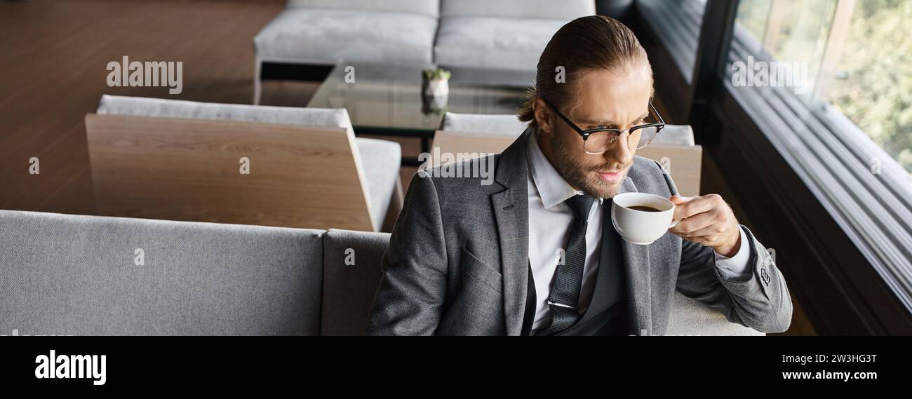 handsome man in smart chic suit with glasses drinking warm tea on sofa ...