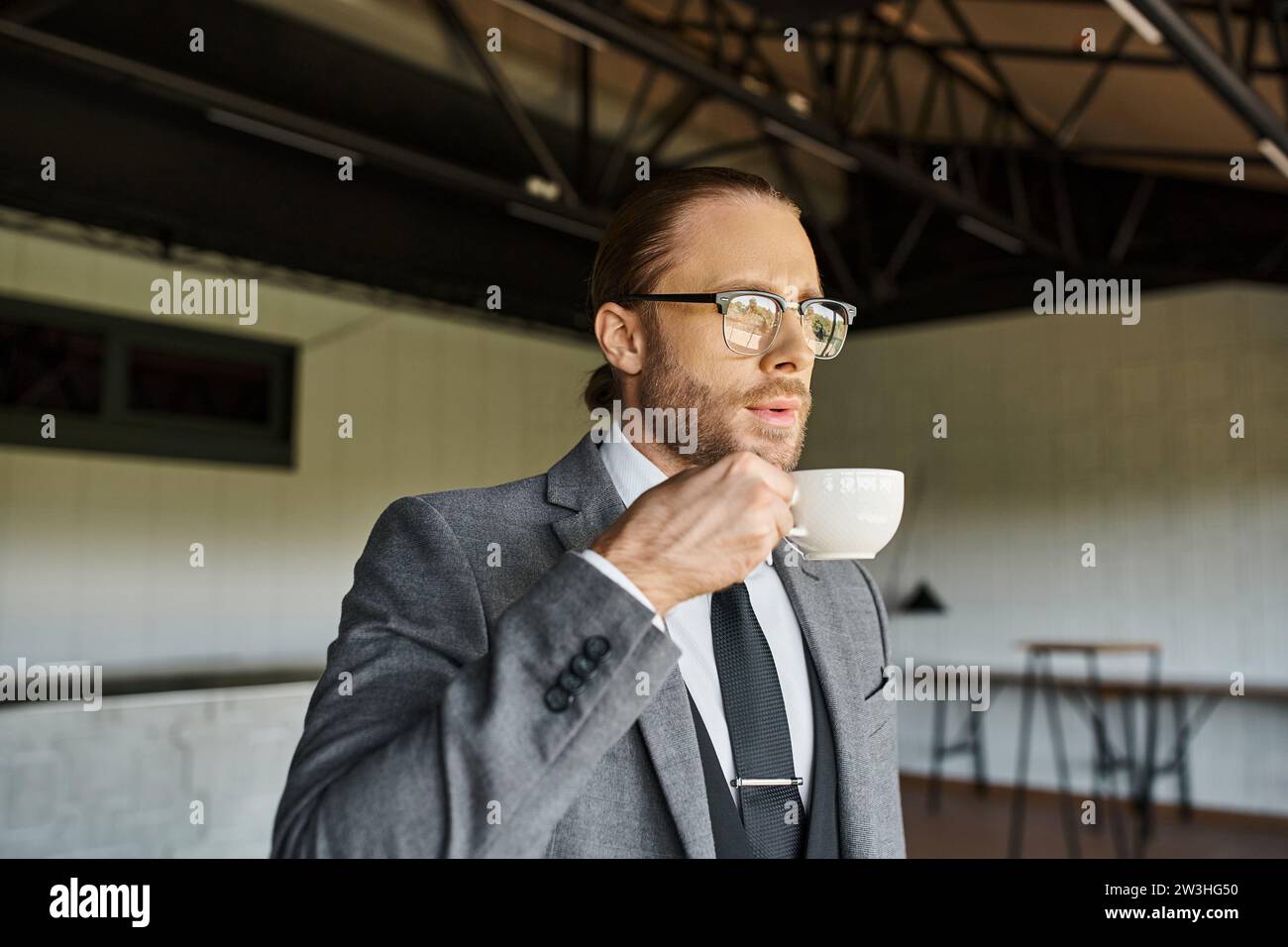 handsome refined professional with glasses and ponytail in smart suit ...