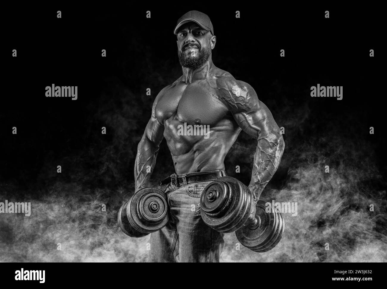 Muscular athlete posing in the studio with dumbbells. Fitness and ...