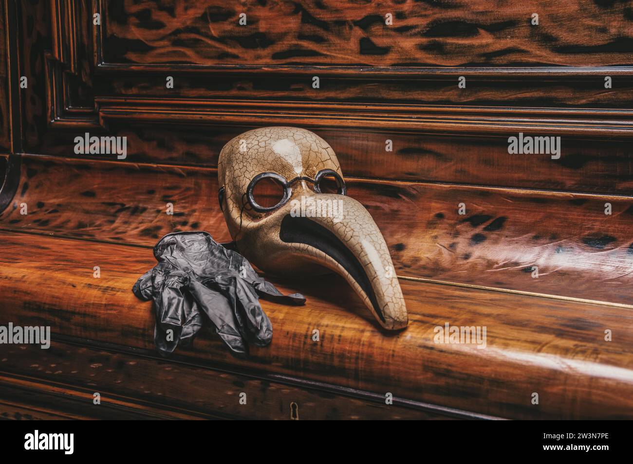 Abstraction of a venetian mask of a doctor lying on the piano keys ...