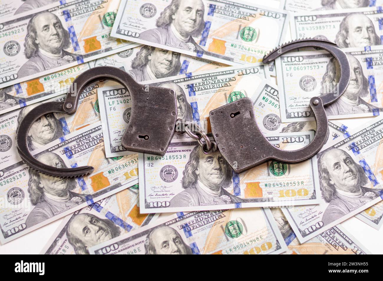 Handcuffs on the background of hundred-dollar bills. Illegal trade ...