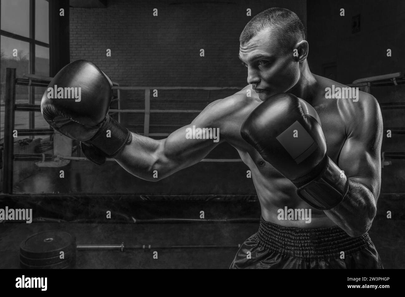 Muscular fighter boxing against the background of the ring. Mixed ...