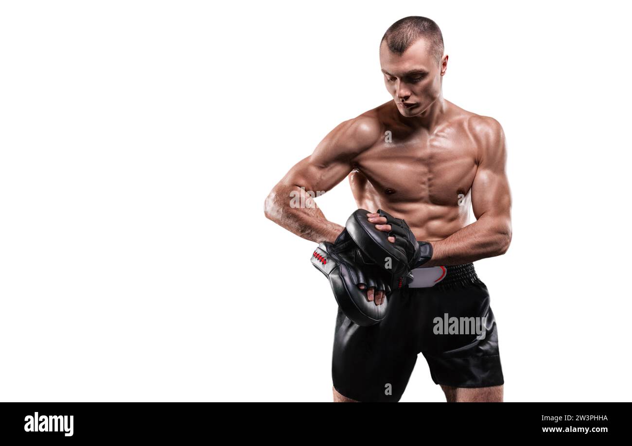 Muscular fighter posing with boxing paws in the studio on a light ...