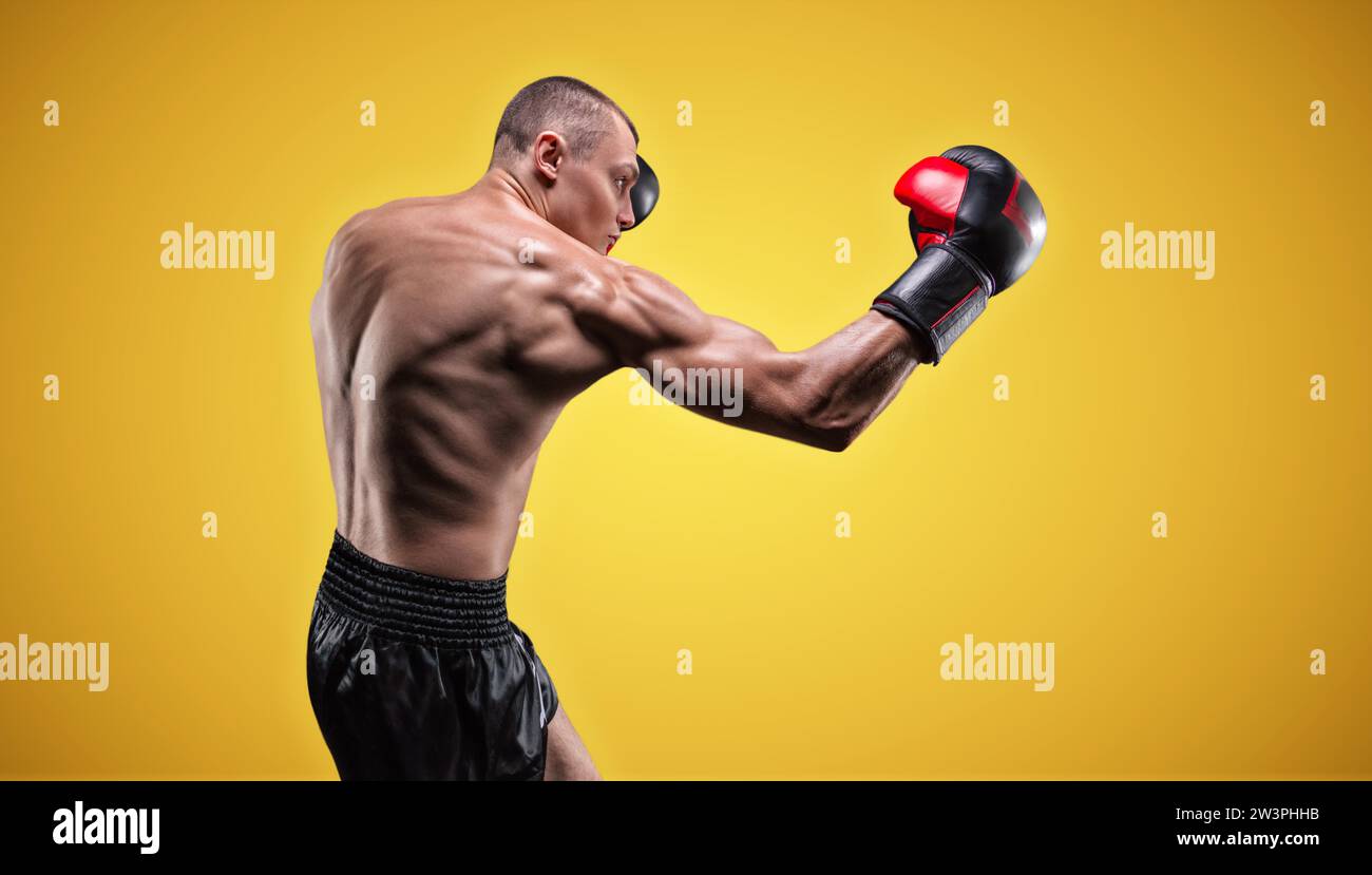 Muscular fighter boxing on a yellow background. Mixed martial arts ...