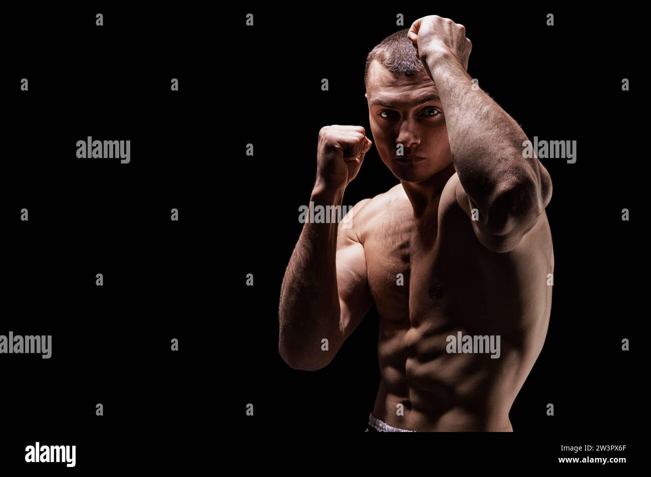 Professional boxer posing in the studio. He stands in front of the ...