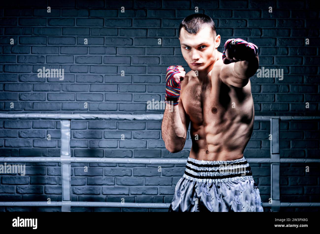 Thai boxer stands in the ring and punches in front of him. The concept ...