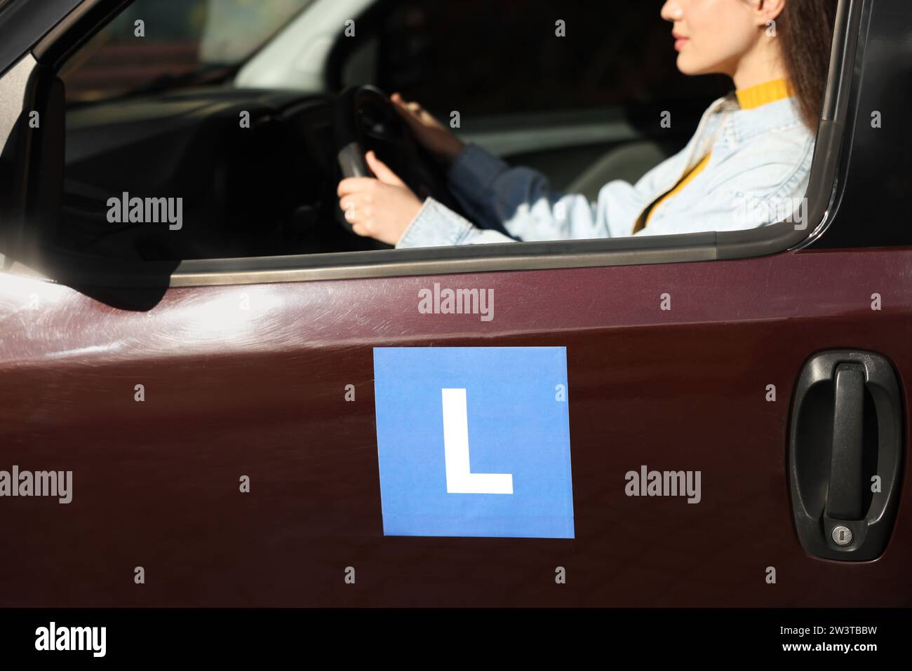 Learner driver driving car with L-plate, view from outside. Driving ...
