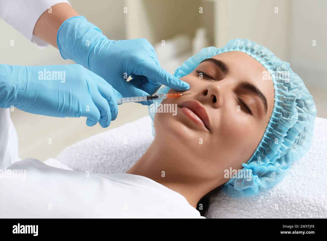 Doctor giving facial injection to young woman in clinic. Cosmetic ...
