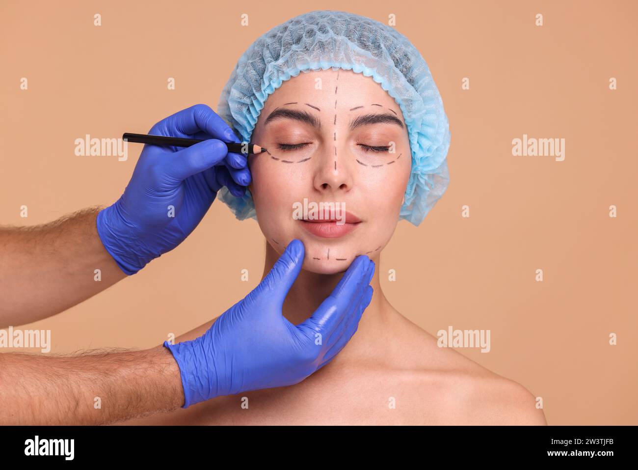 Doctor drawing marks on woman's face for cosmetic surgery operation ...