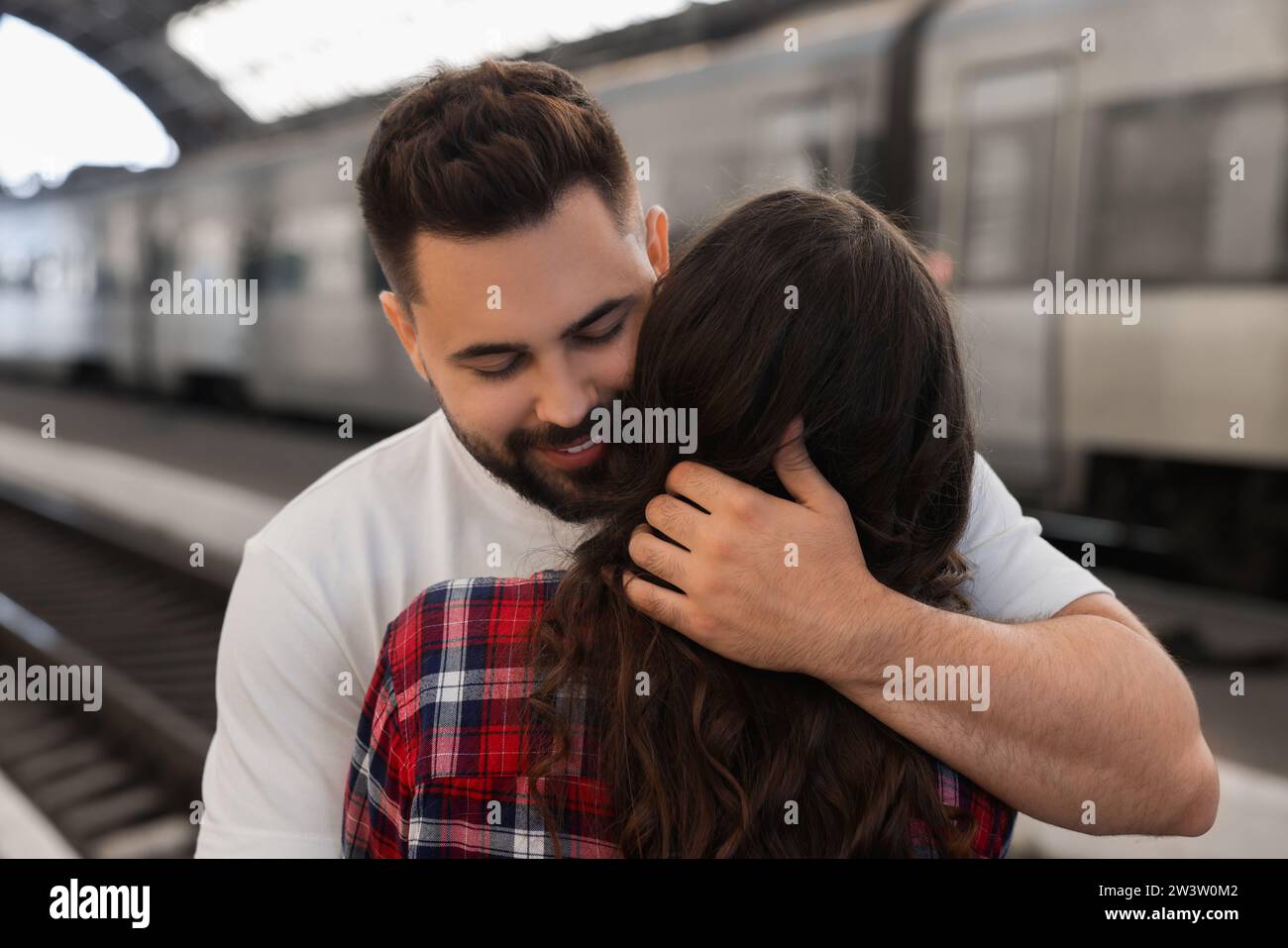 Long-distance relationship. Couple hugging on platform of railway ...