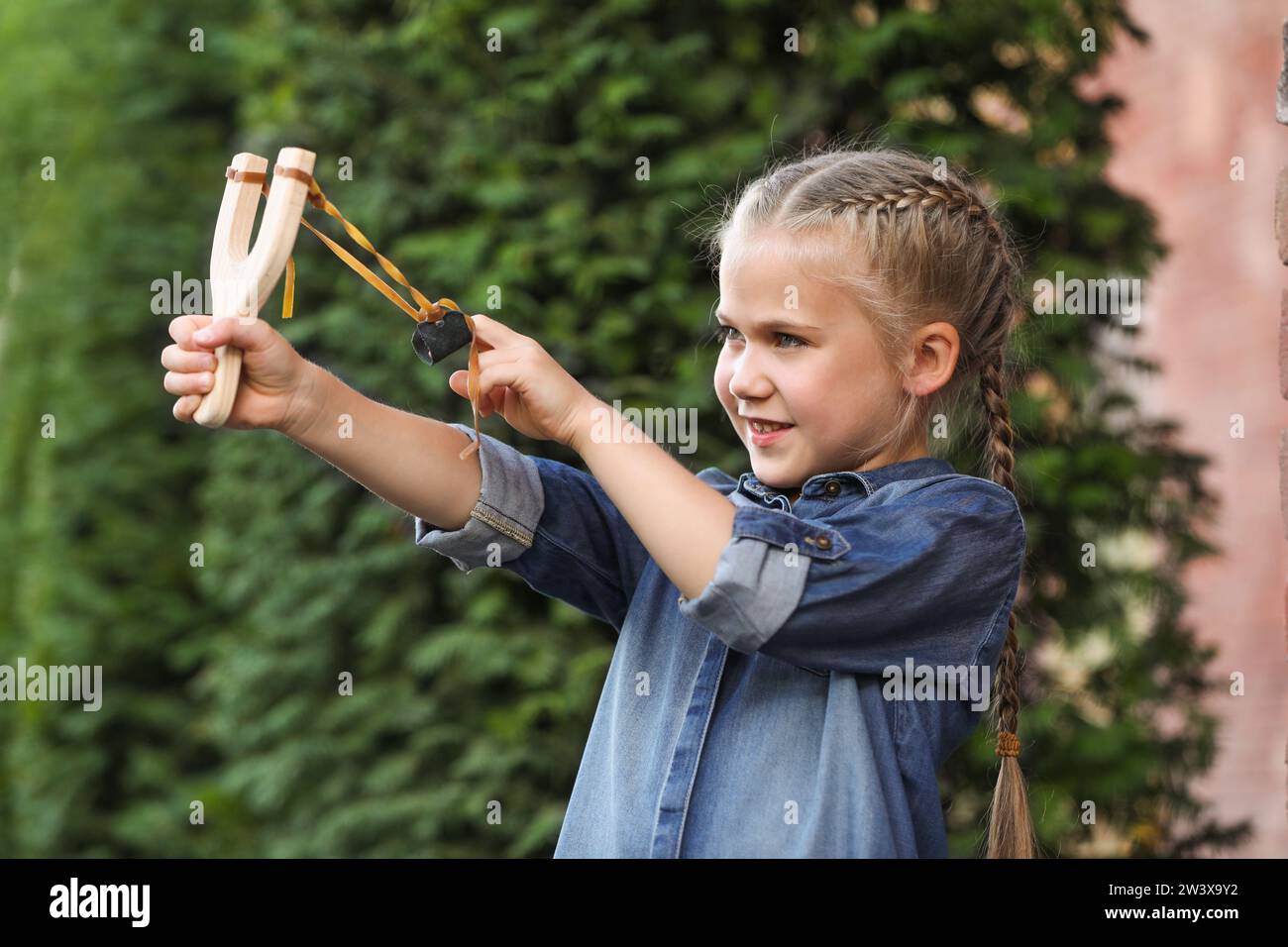 Little girl playing with slingshot outdoors. Kid's toy Stock Photo - Alamy