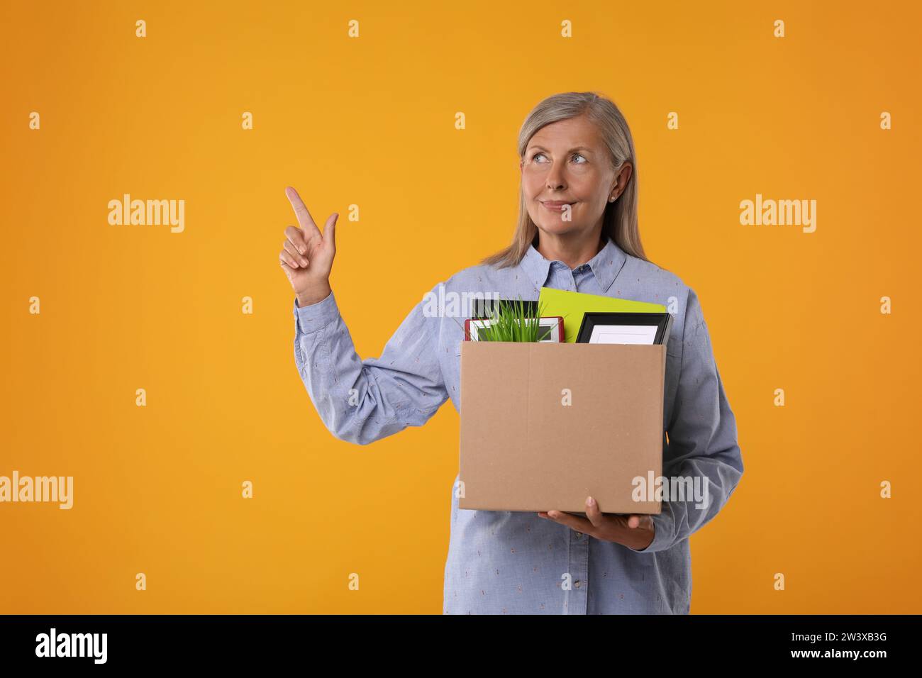 Happy unemployed senior woman with box of personal office belongings on ...