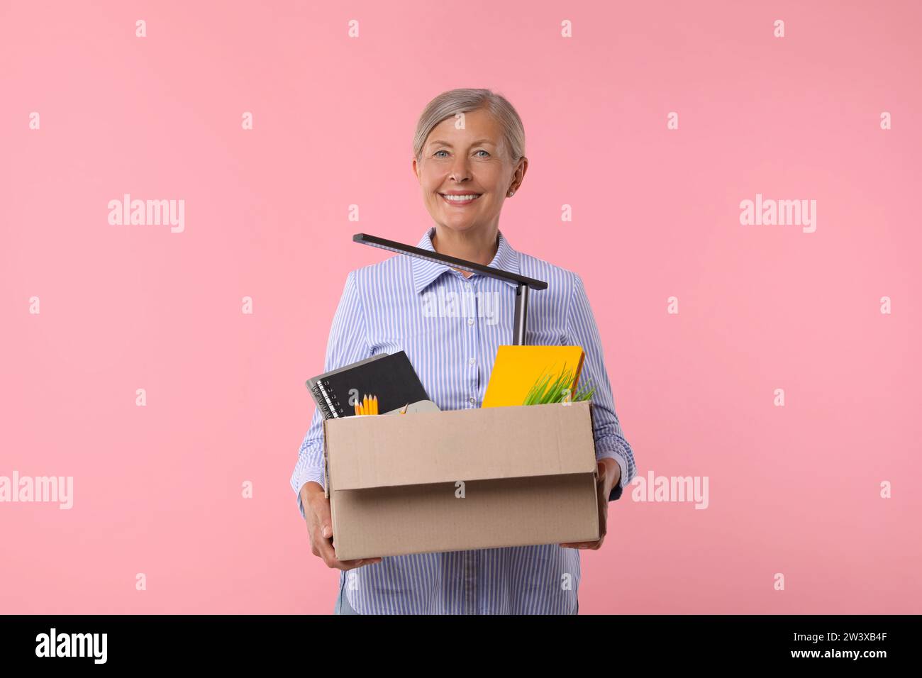 Happy unemployed senior woman with box of personal office belongings on ...